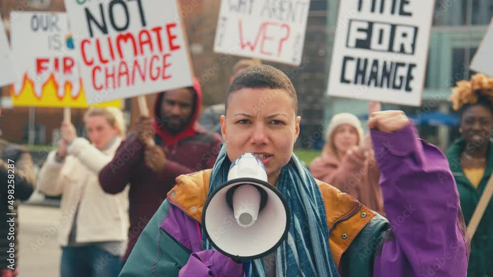 Group of protestors using megaphone holding placards and chanting ...