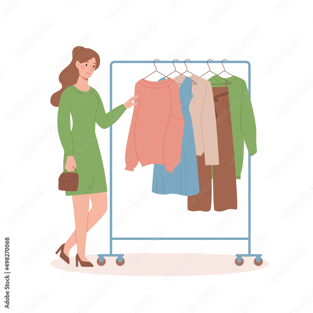 The girl chooses what clothes to wear. A woman in a boutique on ...