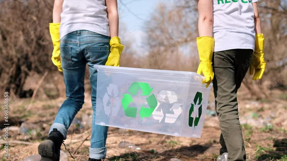 Boy and girl in rubber gloves holding a container at plastic garbage ...