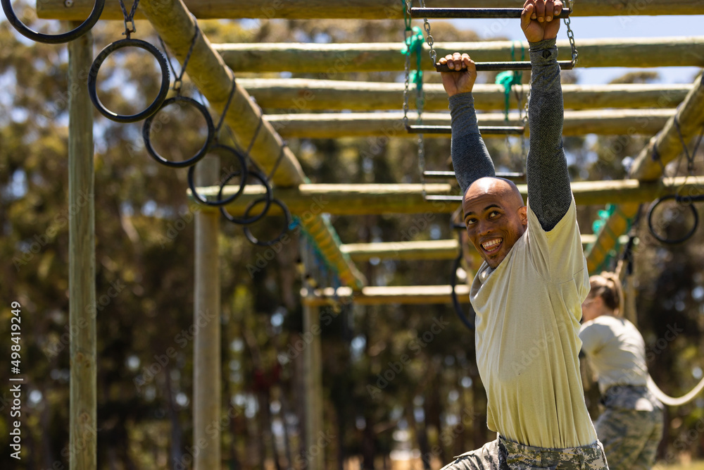 African american male soldier climbing monkey bars during obstacle ...