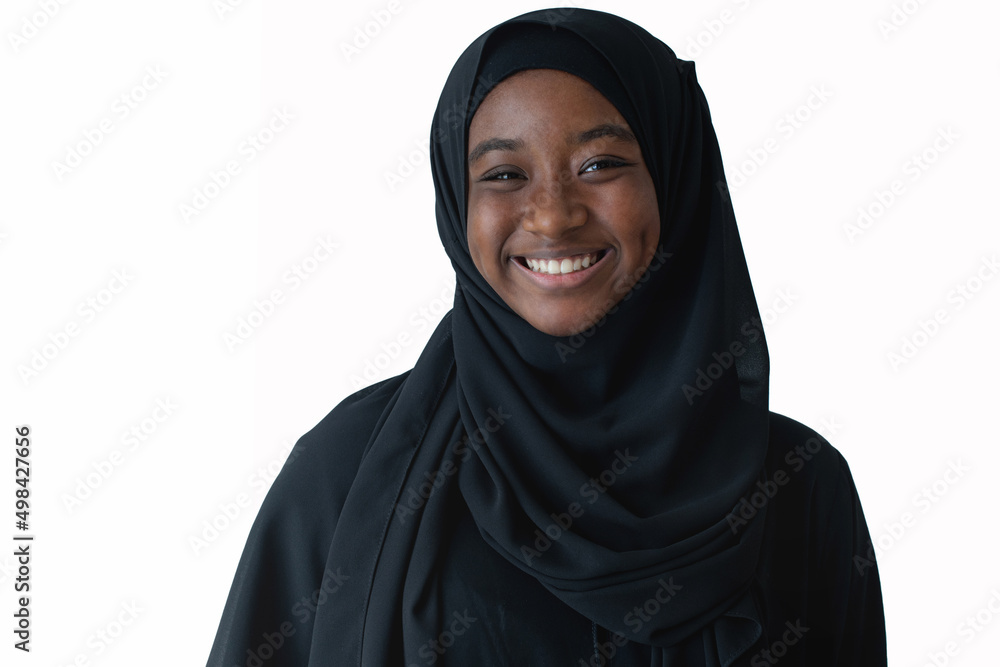 Smiling African Muslim pre-teen wearing black hijab smiling at camera ...