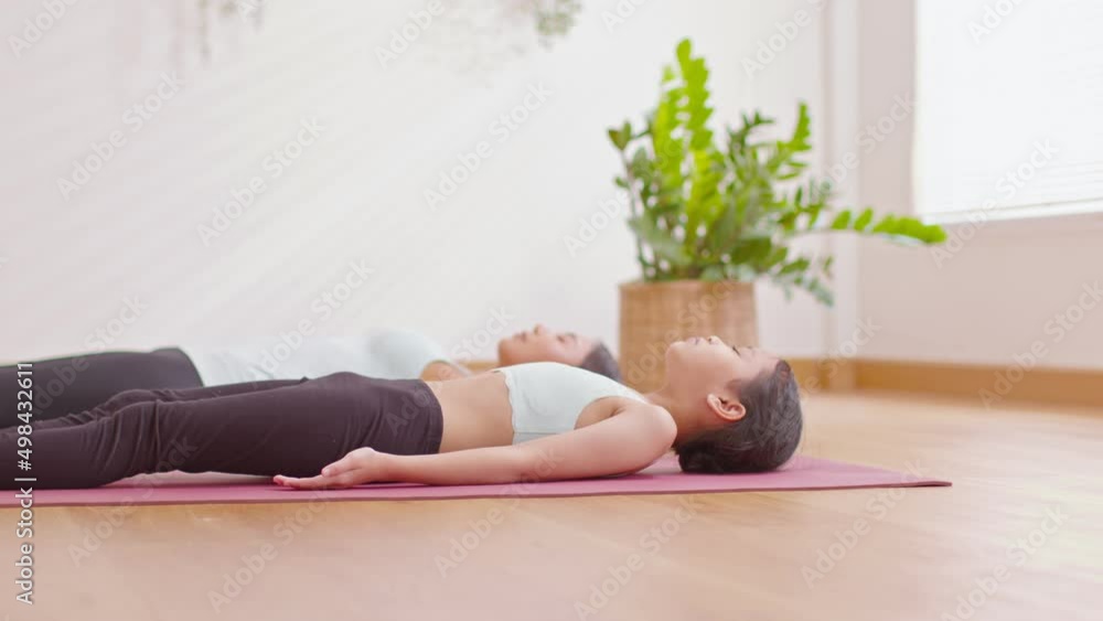 Asian little girl doing yoga dead body pose or nidra meditate with her ...