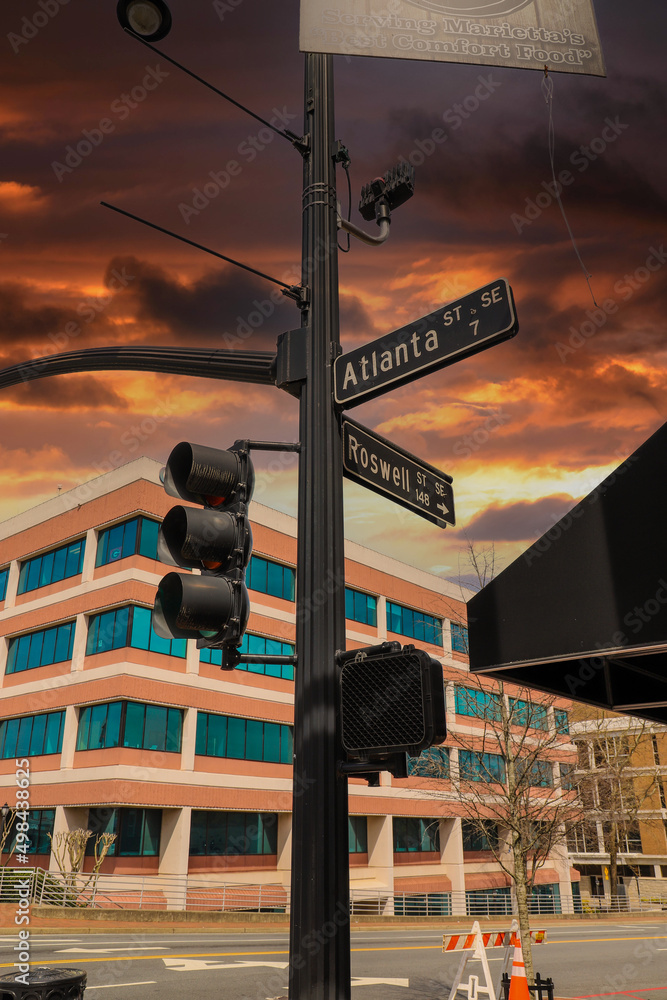 a tall black pole with street signs that read "Atlanta" and "Roswell ...