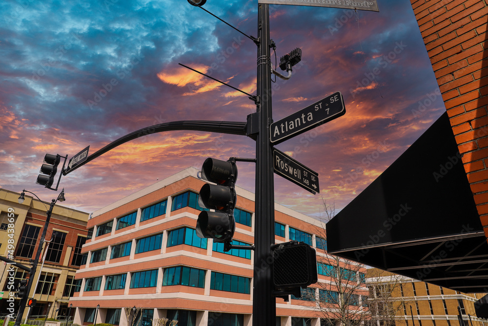 a tall black pole with street signs that read "Atlanta" and "Roswell ...