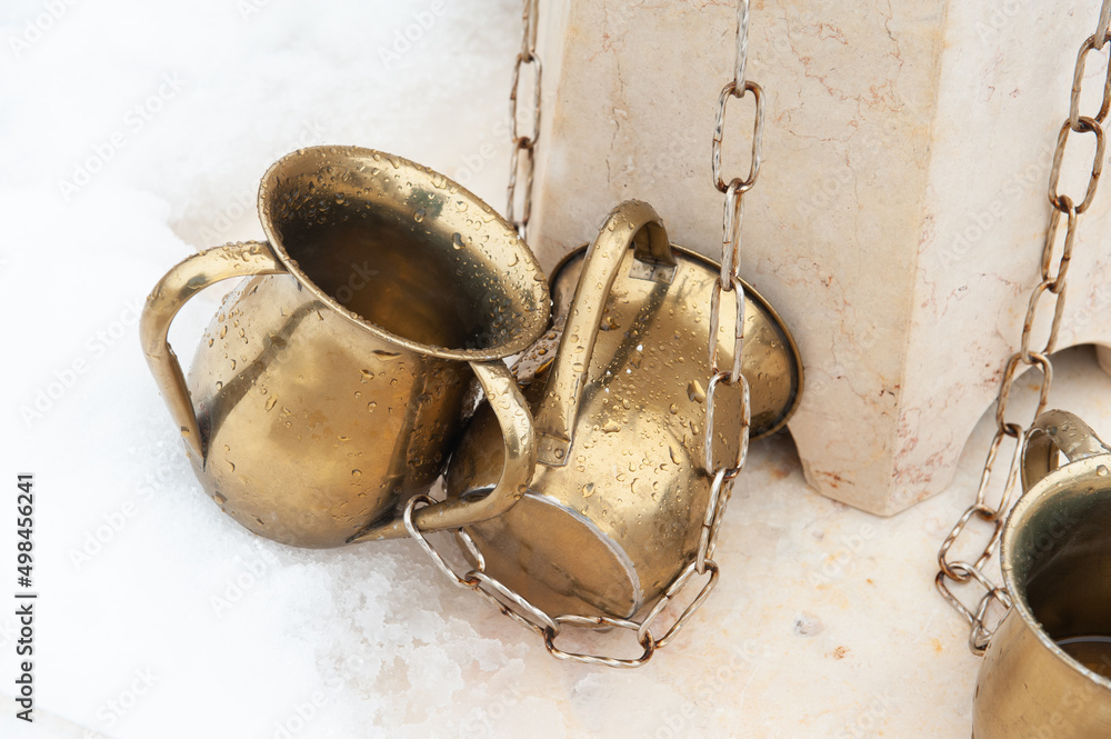 A natla or Jewish ritual hand washing cups lie in a snow-filled sink ...