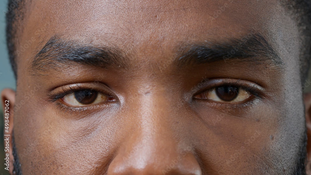 Macro shot of young man showing brown eyes on camera, blinking and ...