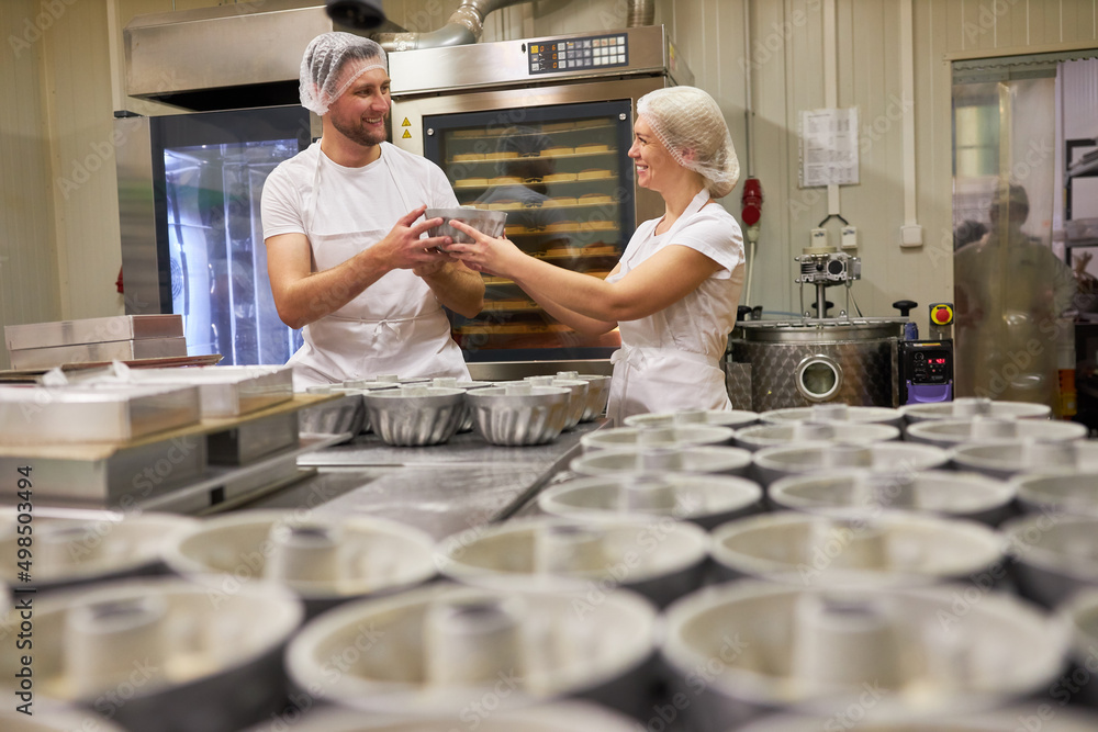 Bakers bake many Gugelhupf cakes in bakery Stock Photo | Adobe Stock