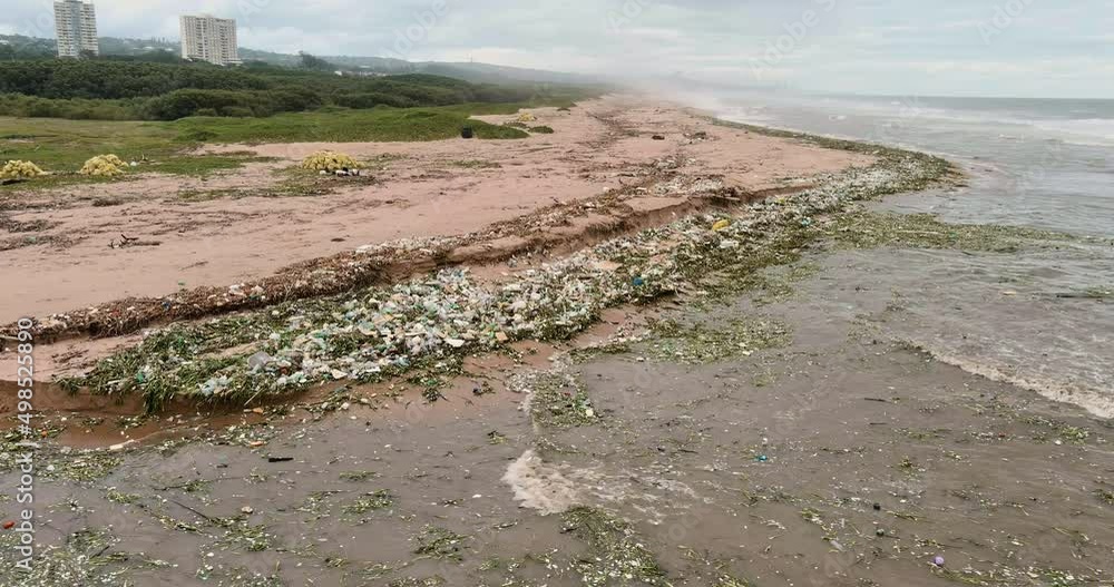 Aerial panning view of plastic pollution flowing down a river mouth ...