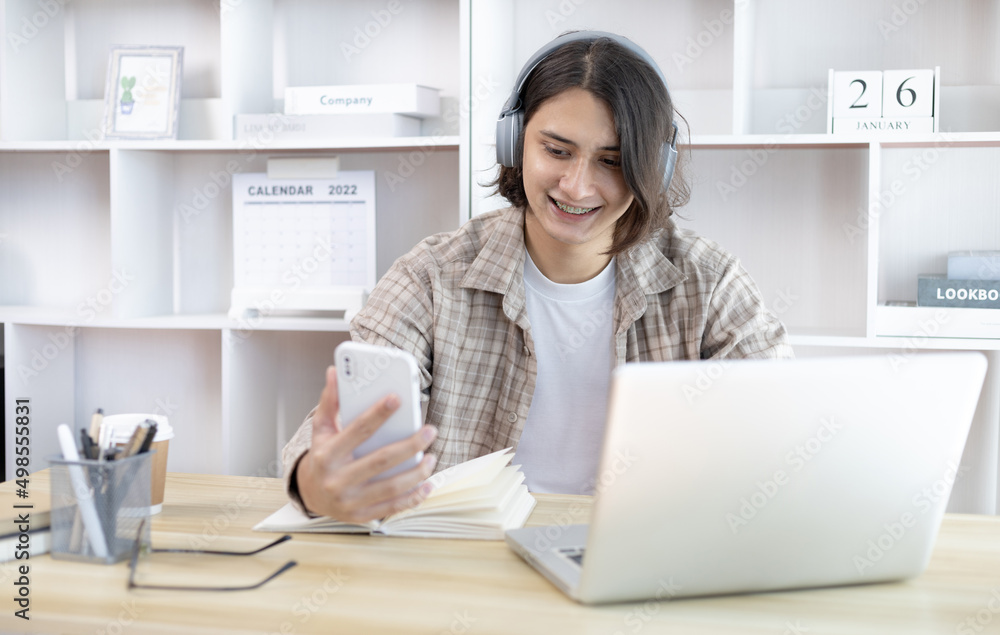 Young student does his homework and is broadcast live on his laptop ...
