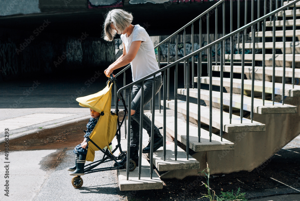 Woman lifts stroller on steps of street stairs and lack of ramp Stock ...