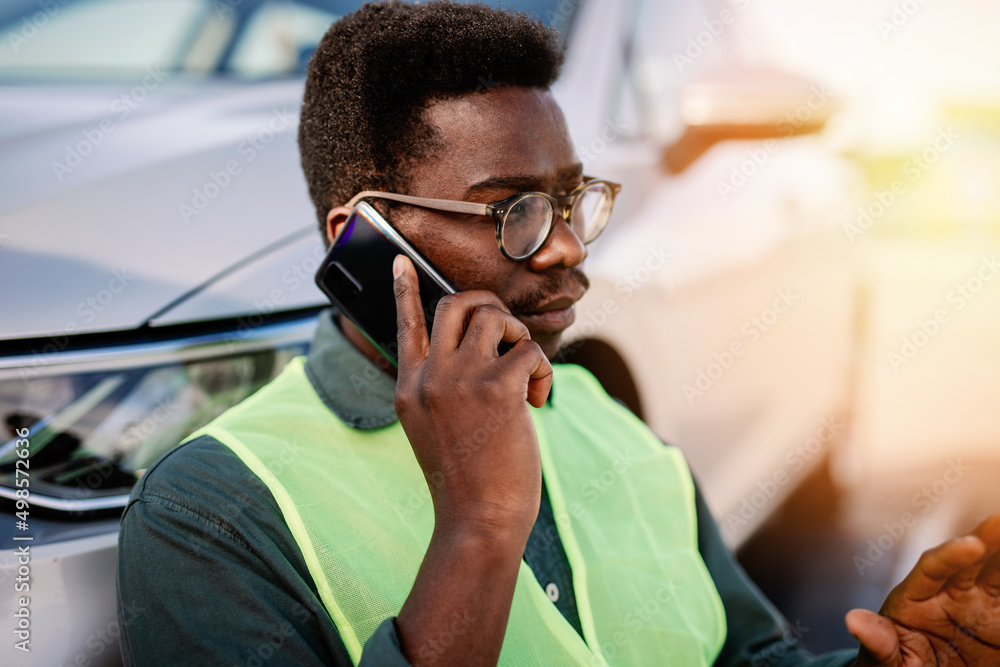 Young African American man calling towing service for help on the road ...
