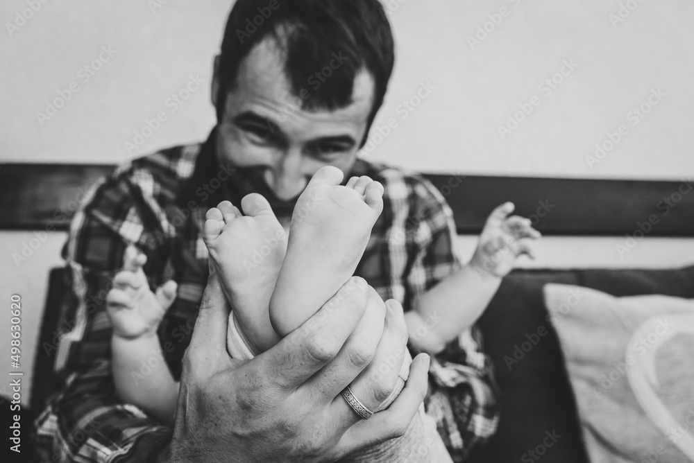 Little son's legs in dad's hands. Portrait of dad playing with baby boy ...