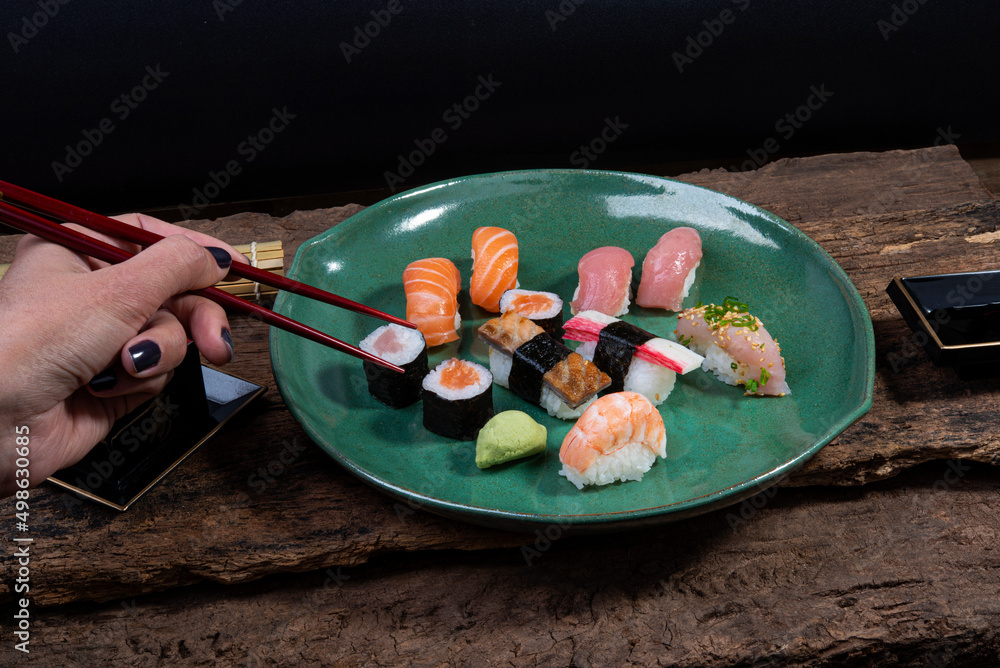 holding chopsticks - nigiri sushi and hossomaki - salmon, tuna, kani ...