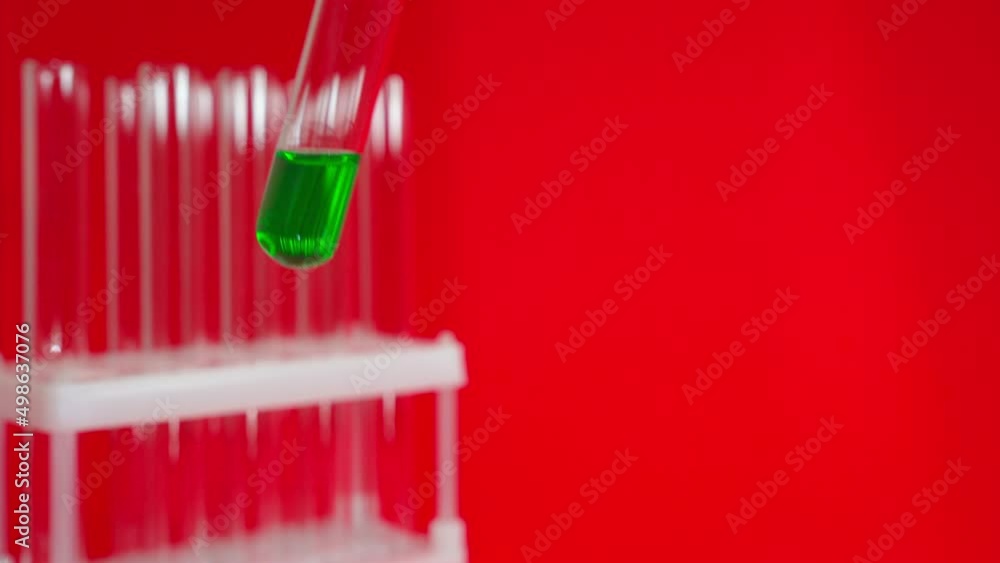 Close up view of transparent glass test tube with green liquid inside ...