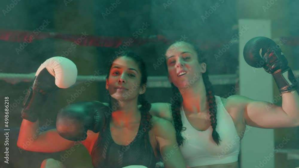 Two female boxers posing at camera, showing strength gesture with their ...