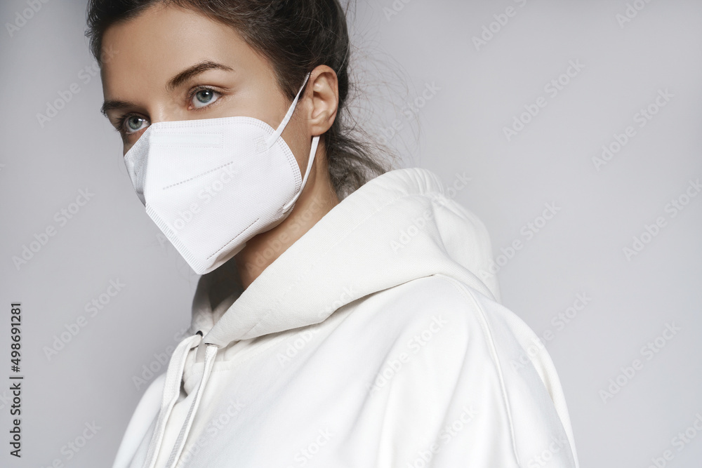 Photo & Art Print Young woman wearing white hoodie and ffp2 respirator ...