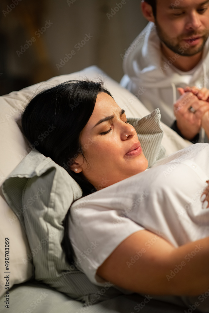 Foto de Focused woman giving birth at home. Woman with pierced nose ...