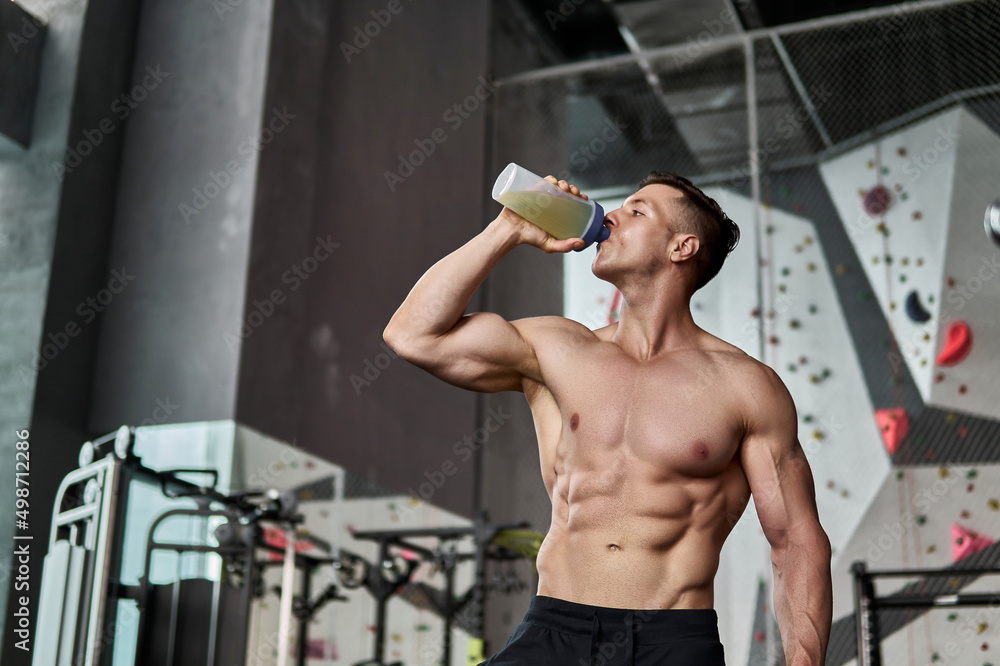 Muscular man drinking energy drink in gym. Stock Photo | Adobe Stock