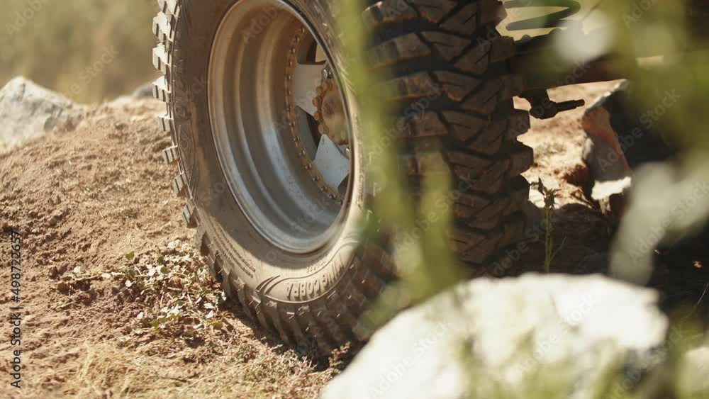 Closeup of wheels an SUV driving down incline on off road, side view ...