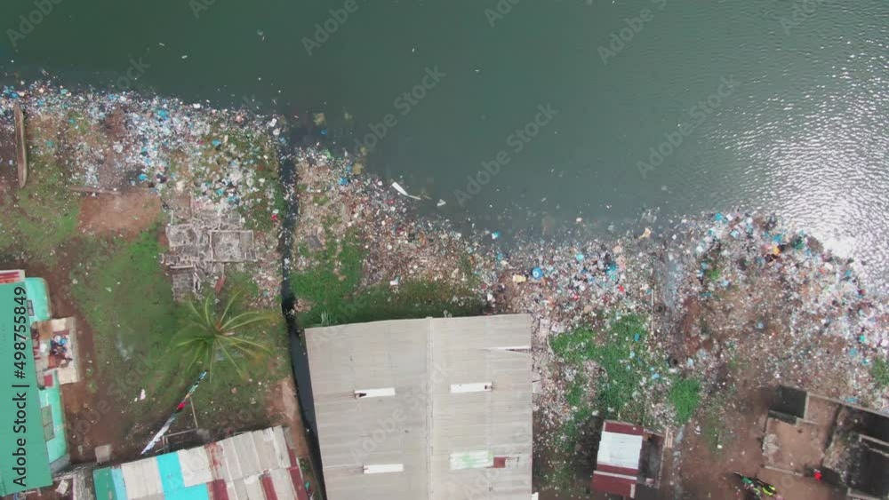 a lot of plastic pollution at the ocean near a poor slum area in ...