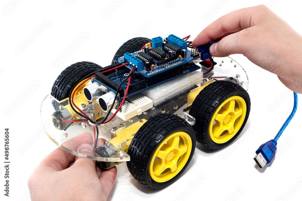 Hands holding programmable robotic car with obstacle avoidance and line ...