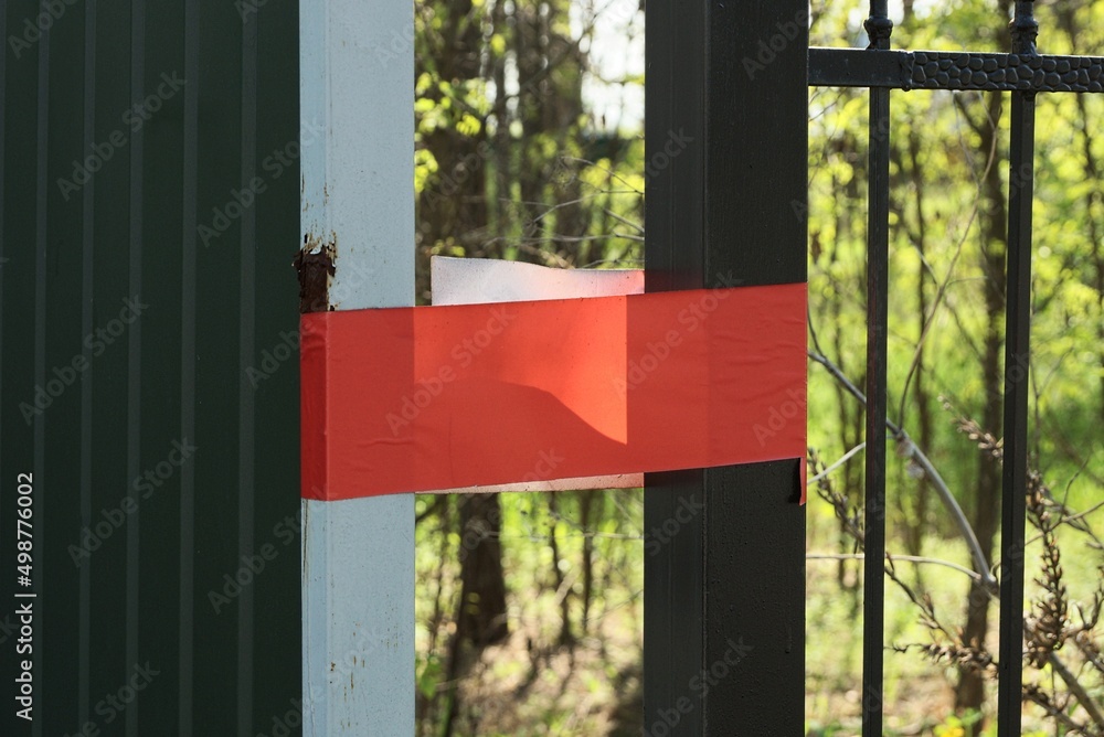 part of a metal fence made of black and gray iron bars with red tape ...