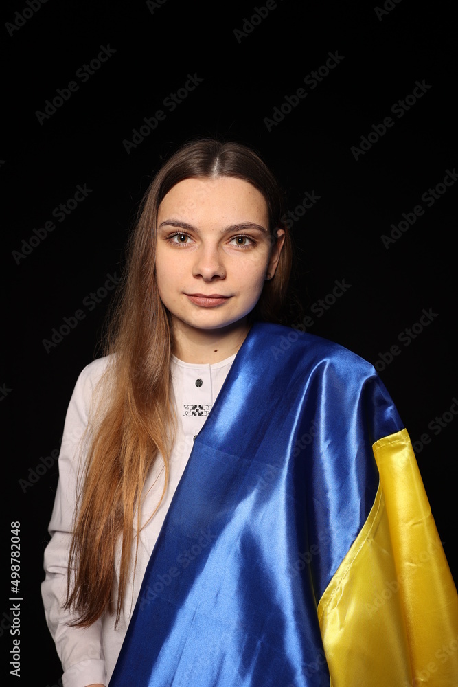 beautiful girl with the flag of Ukraine on a black background. war in ...