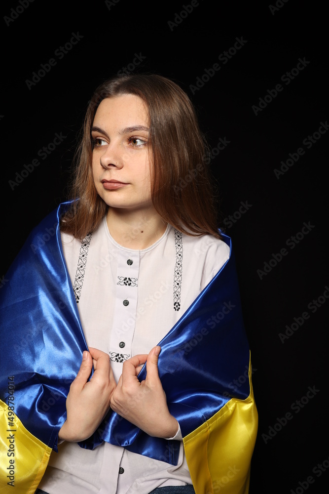 beautiful girl with the flag of Ukraine on a black background. war in ...