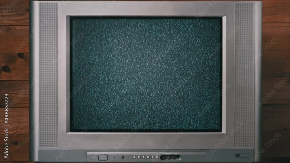 Static noise on the screen of an old CRT TV on wooden background. Zoom ...