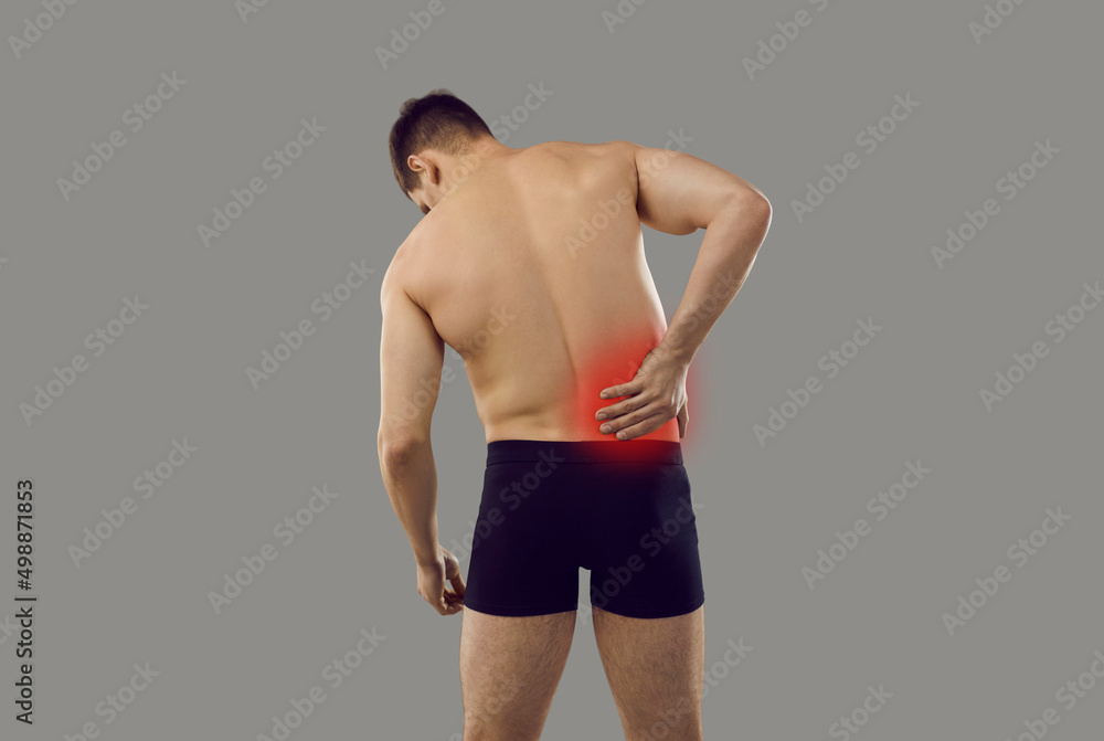 Backside of young man suffering from pain in right side. Patient in ...