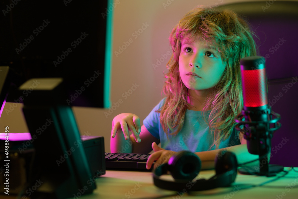 Kid using pc at night. A pretty child learns a lesson using a desktop ...