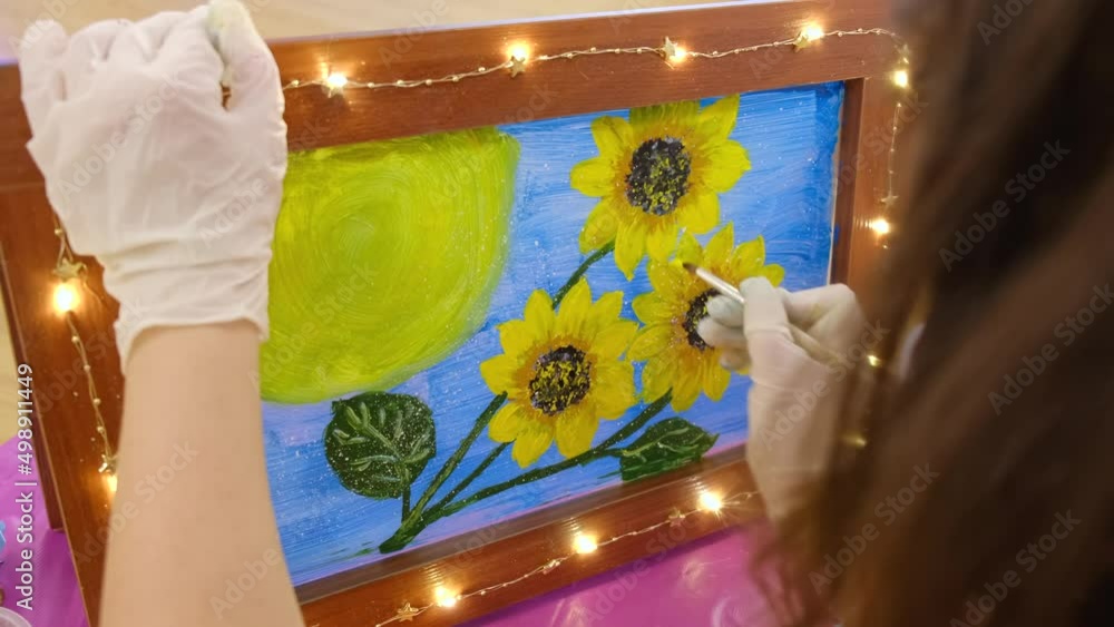 Close-up of a girl drawing with paint on glass. Non-traditional ...