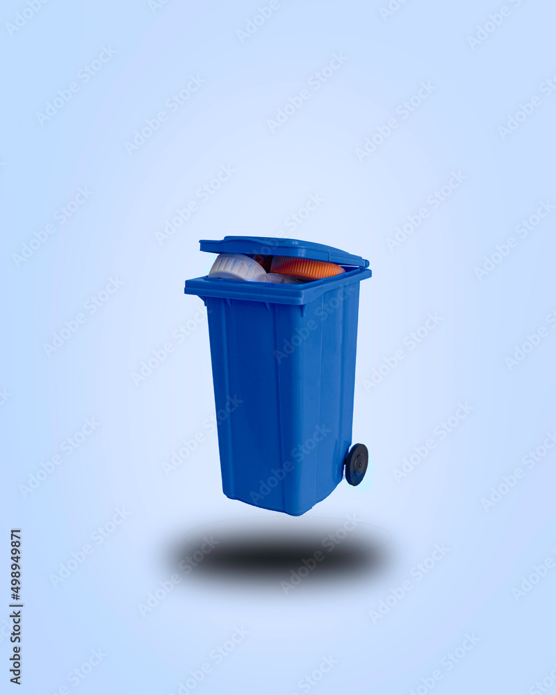 Floating trash can in pastel background. Plastic plugs in garbage can ...