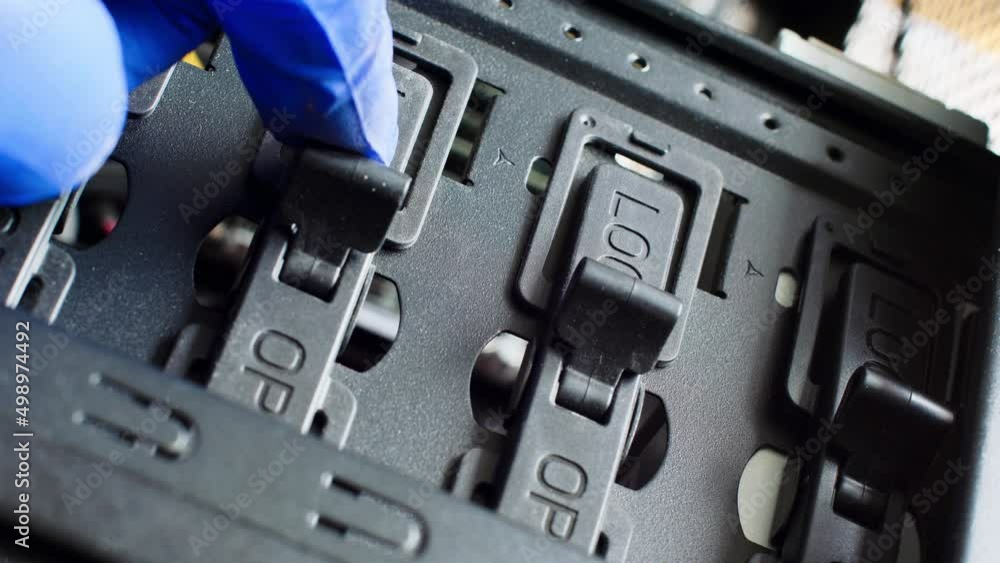 A blue gloved hand opens the switches from the Lock to the Open ...