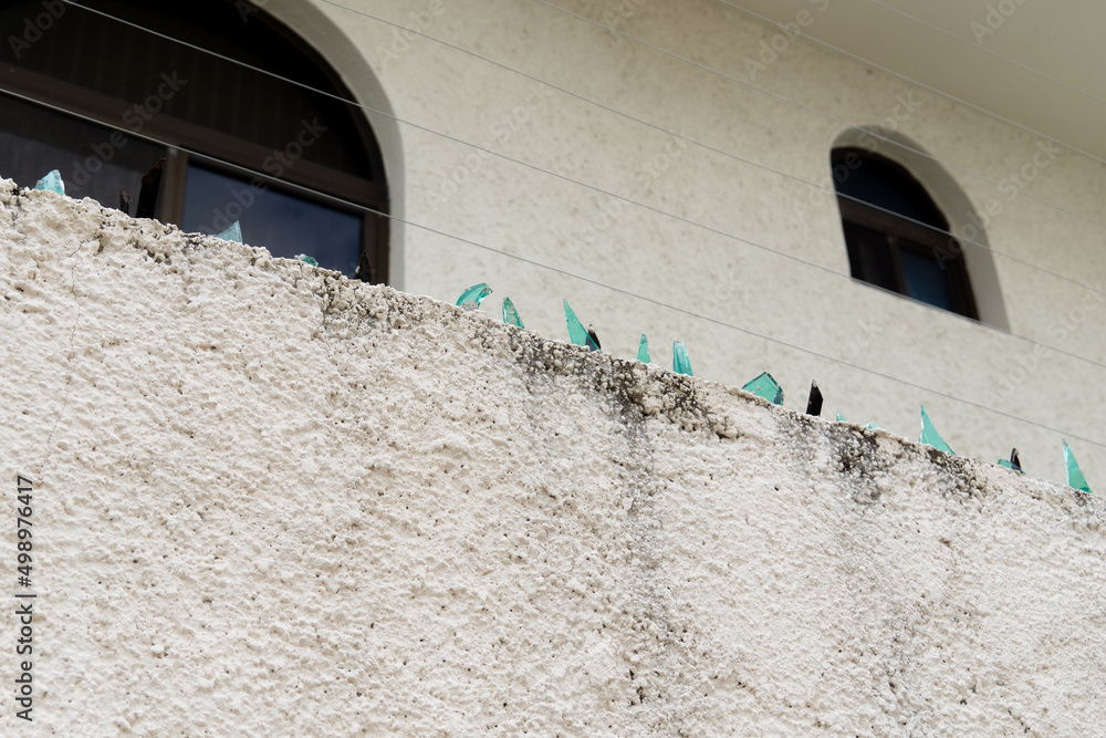 Broken glass on the cement walls. Field of a concrete fence with broken ...