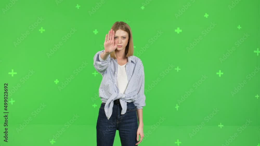 Close up of female Model standing doing stop sign over green screen ...