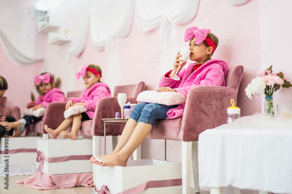 Beautiful little girl in children spa center enjoying her treatment ...
