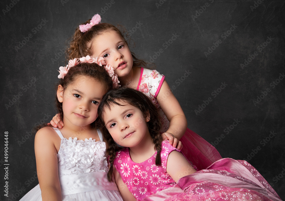 Portrait three little girl sisters siblings in fancy party dresses ...