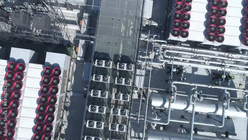 Overhead look down. Datacenter roof with rooftop fans, piping and tanks ...
