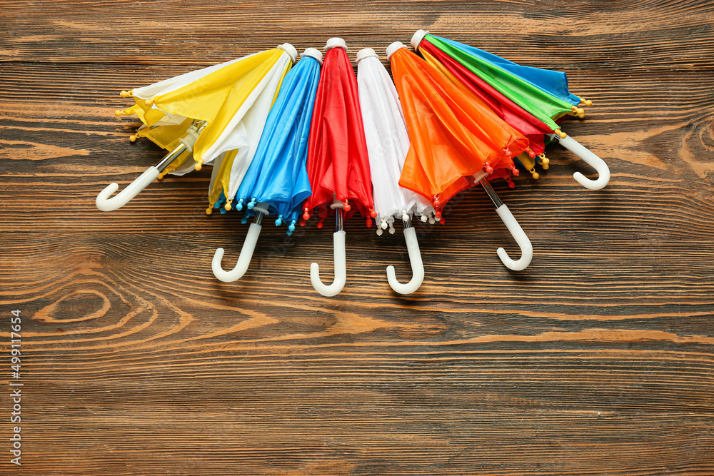 Different umbrellas on wooden background Stock Photo | Adobe Stock