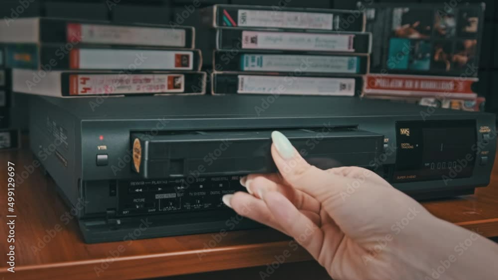 Insert VHS cassette into VCR and push play button. Black vintage ...