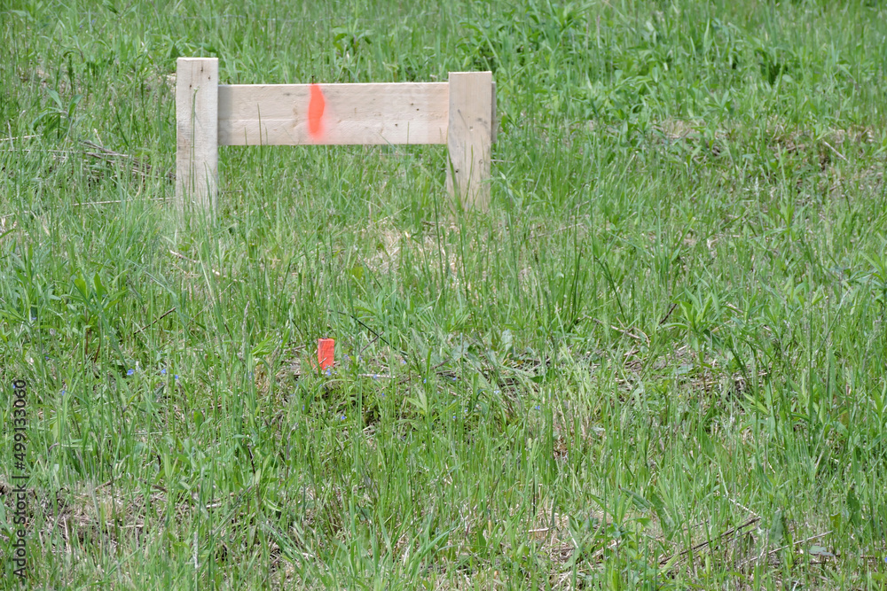 A batter-board and a wooden stake used for marking corners of a new ...