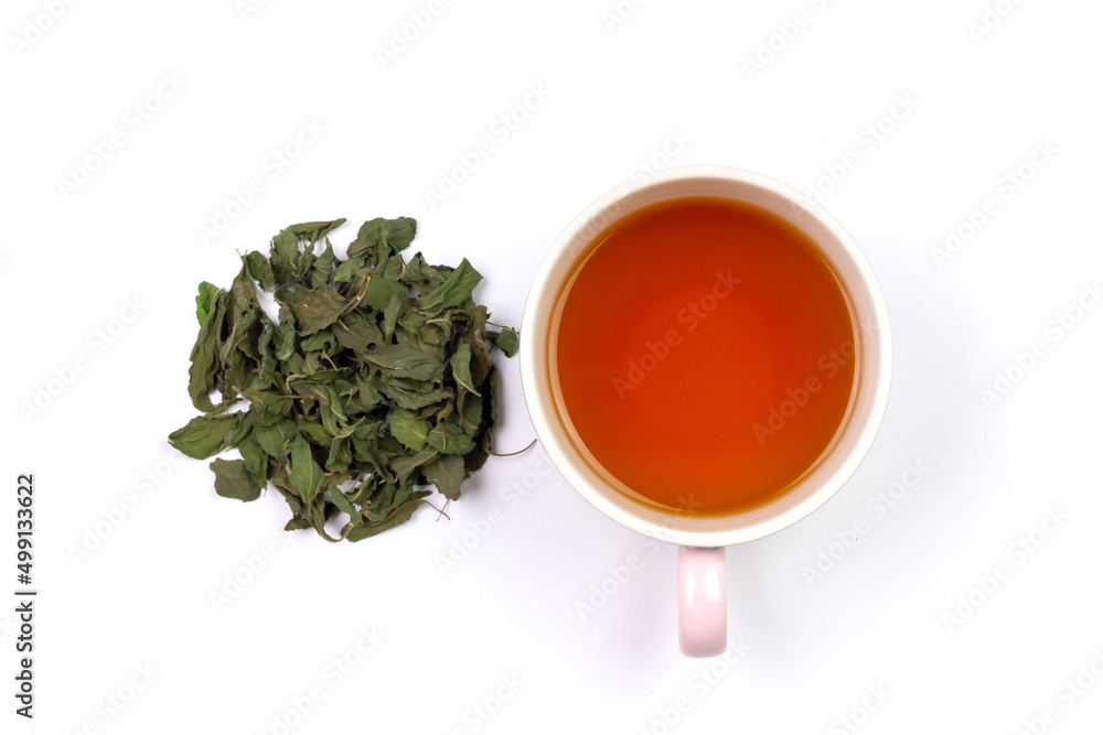 Tulsi or holy basil tea in white cup with pile of dried tulsi leaf ...
