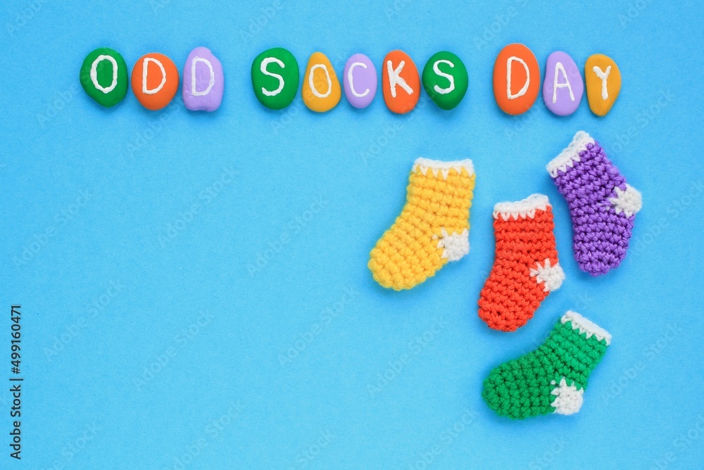 Odd socks day lettering and mismatched colourful socks on blue background. Social school ...