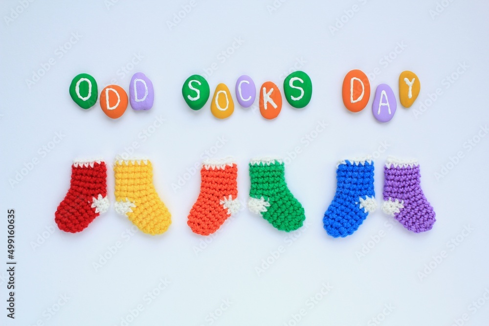 Odd socks day lettering and mismatched colourful socks on white ...