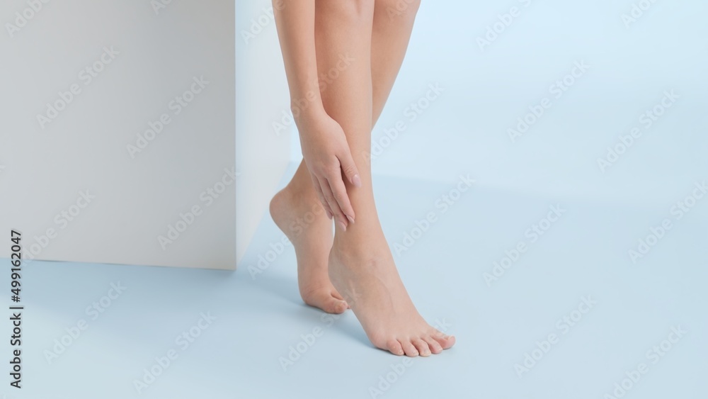 Horizontal close-up shot of good-looking female legs. Woman strokes her ...