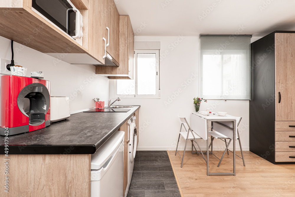 Kitchen with dark gray wood countertops with wood cabinets and white ...