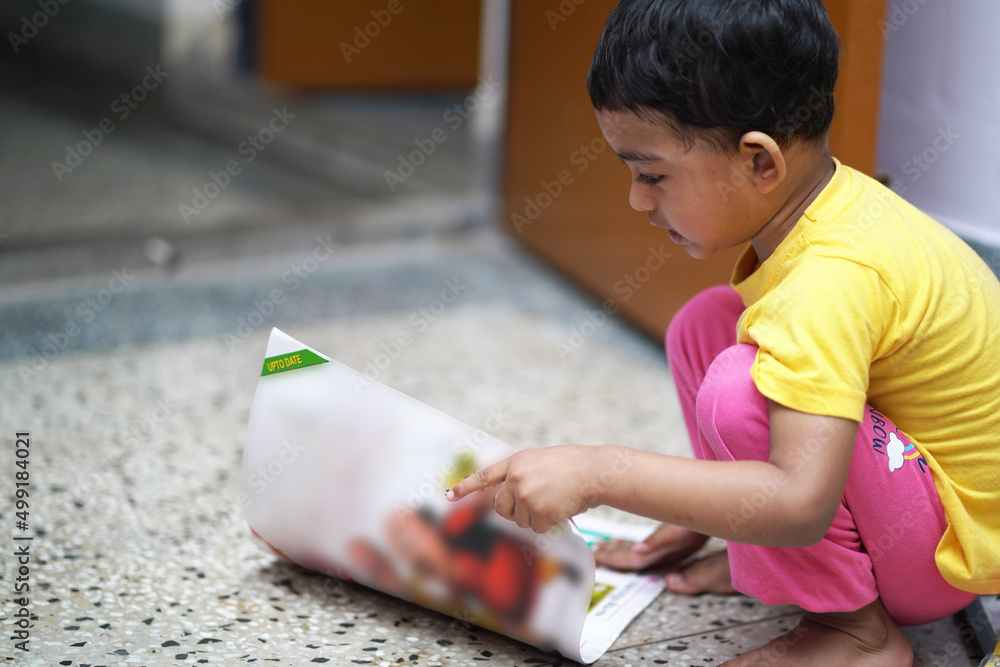 a baby boy reading from his nursery rhyme story book. toddler education ...