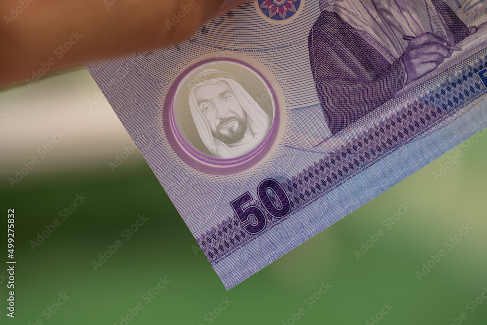 Persons hand giving the Currency of the United Arab Emirates (UAE ...