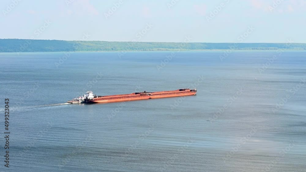 An articulated tugboat and barge bulk carrier transports sand and ...